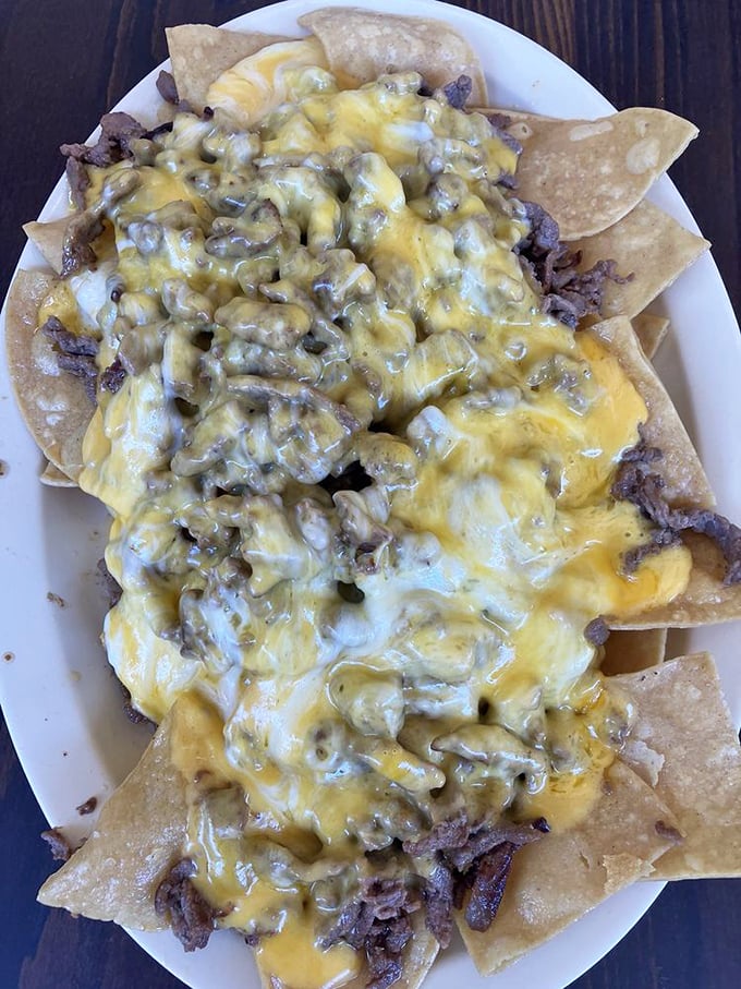 These nachos aren't playing around—they've committed to a serious relationship with cheese and green chile that would make lesser chips crumble under pressure.