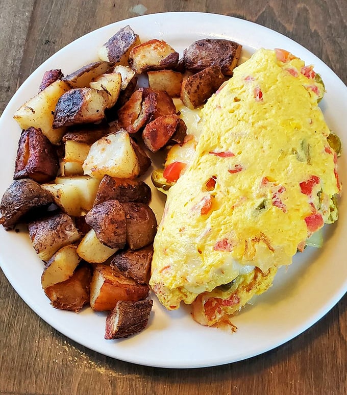 Behold the omelet that dreams are made of—studded with colorful vegetables and paired with home fries that could make a potato farmer weep with pride.