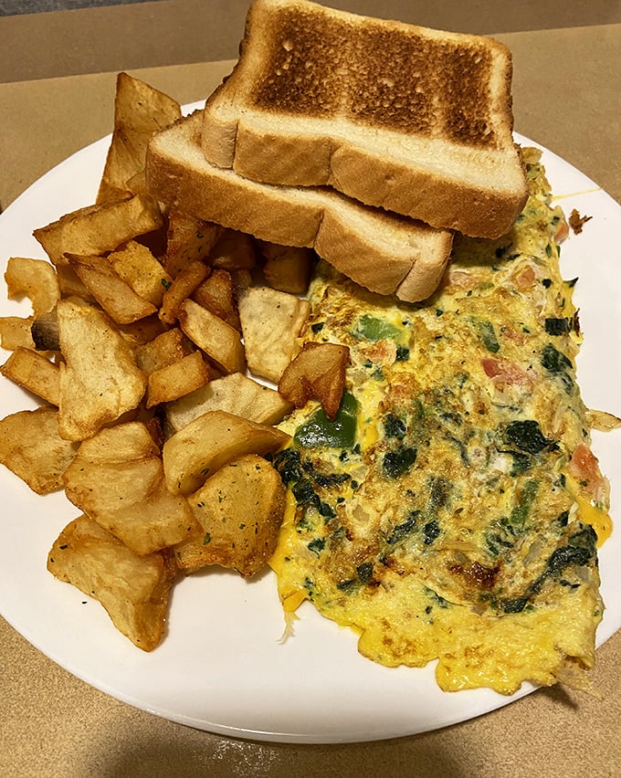 An omelet that's seen things—namely cheese, vegetables, and proper technique. Those home fries are the unsung heroes of the plate.