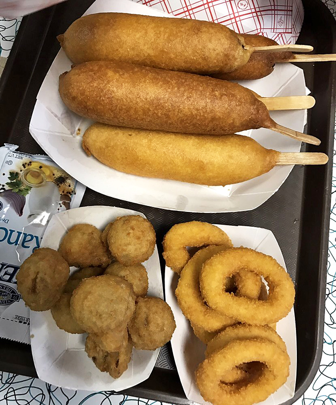 Three Cozy Dogs with onion rings and mushrooms – a tray that says "I'm on vacation and my diet starts when I cross state lines."