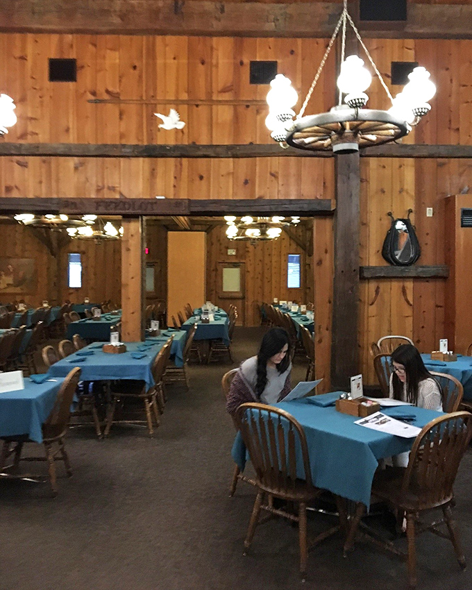 Blue tablecloths pop against the rustic wooden interior, creating dining spaces that feel both spacious and intimate—like your favorite country inn.