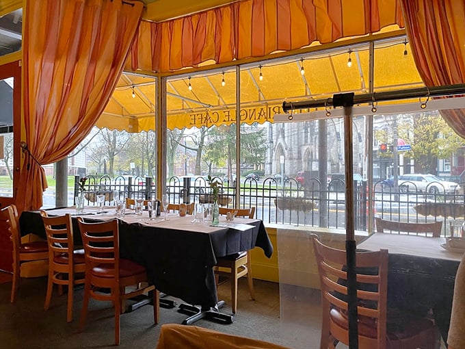 Sunlight streams through orange curtains, painting the dining room in warm hues. These tables have witnessed countless first dates, anniversaries, and "just because" celebrations.