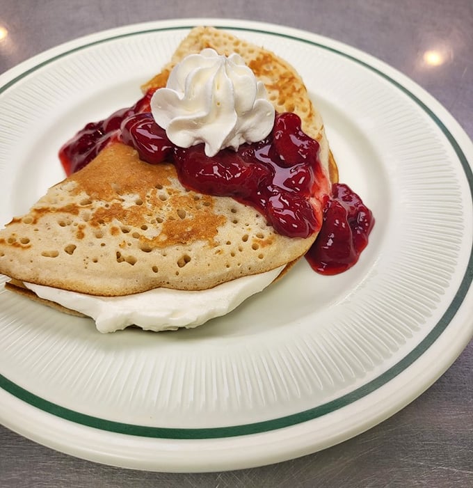 These aren't just pancakes; they're fluffy canvases for berry artistry, where whipped cream is the essential finishing touch.