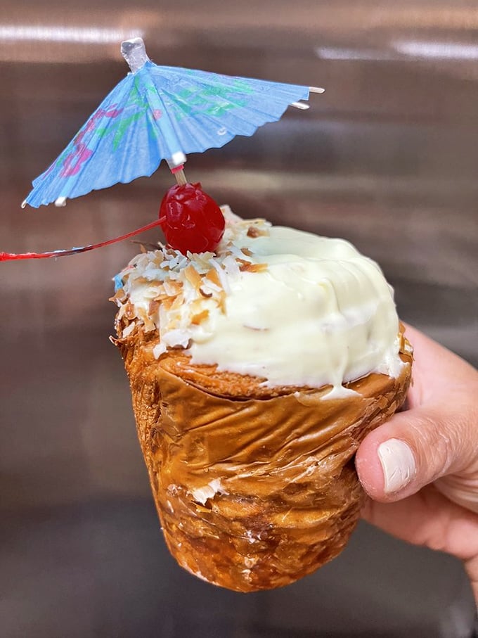 Vacation in pastry form. This piña colada creation with its tiny umbrella isn't just cute—it's a tropical getaway for your taste buds.