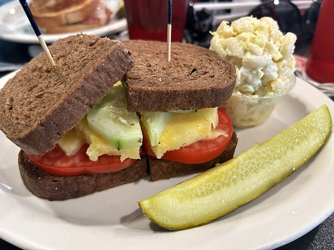 The sandwich that proves simplicity is genius—fresh vegetables between hearty bread with that pickle standing guard like a crunchy sentinel.