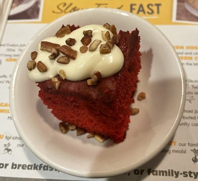 Red velvet cake topped with cream cheese frosting and pecans—proof that Fred's understands dessert isn't just the end of a meal, but a grand finale.