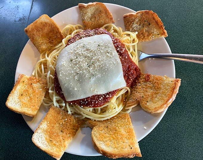 Spaghetti surrounded by a golden garlic toast fortress—carb heaven that would make your Italian grandmother nod in approval.