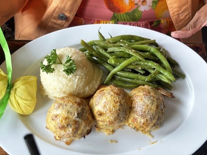 Three perfectly golden stuffed shrimp standing at attention beside rice and green beans—comfort food that's dressed up for a night out.