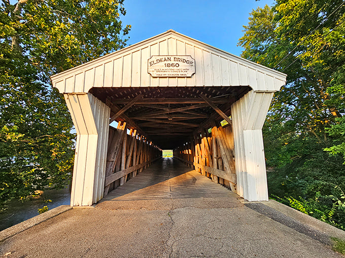 Summer's greenery frames the entrance perfectly, creating that "gateway to somewhere special" feeling that makes covered bridges so appealing.