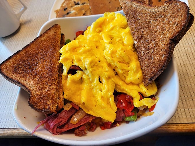Scrambled eggs nestled among toast and what appears to be corned beef—a breakfast bowl that says "today is going to be extraordinary."