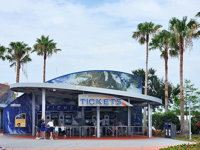 The futuristic ticket booth, framed by swaying palm trees, serves as the gateway to humanity's greatest adventure.