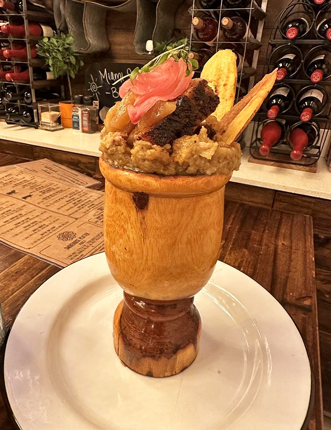 This wooden vessel holds what appears to be a culinary tower of Babel. It's architectural food that makes you wonder whether to photograph or devour first.