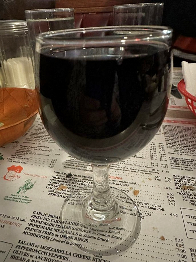 Wine in a stemmed glass on a checkered tablecloth—some traditions exist because they're perfect. Simple pleasures are often the most satisfying.