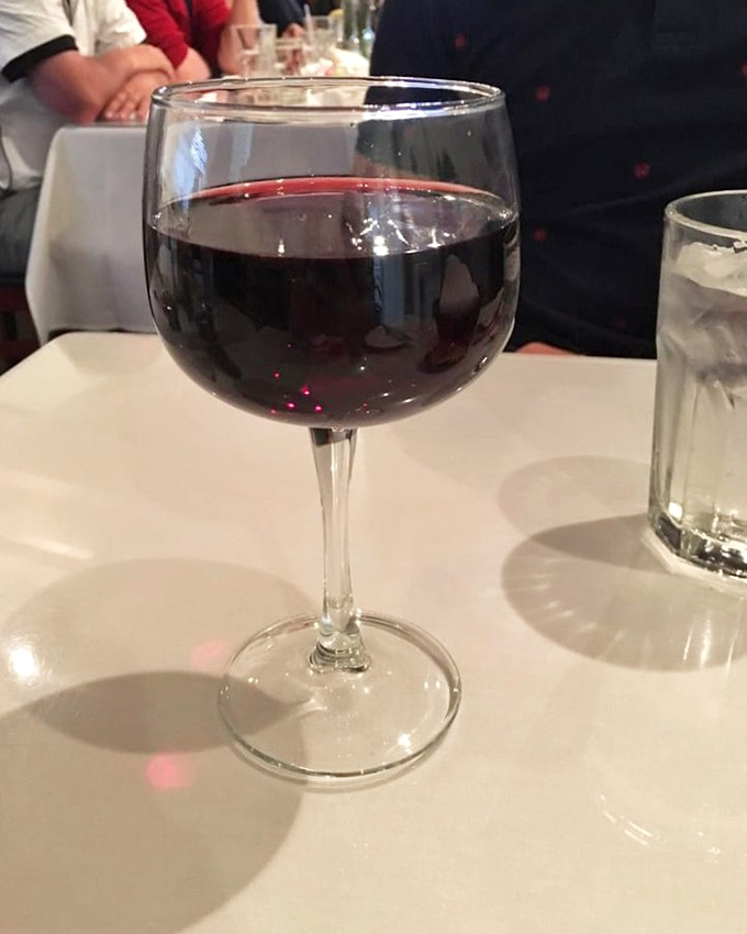 A glass of ruby-red wine—the perfect companion for seafood adventures. Simple pleasures are often the most profound.