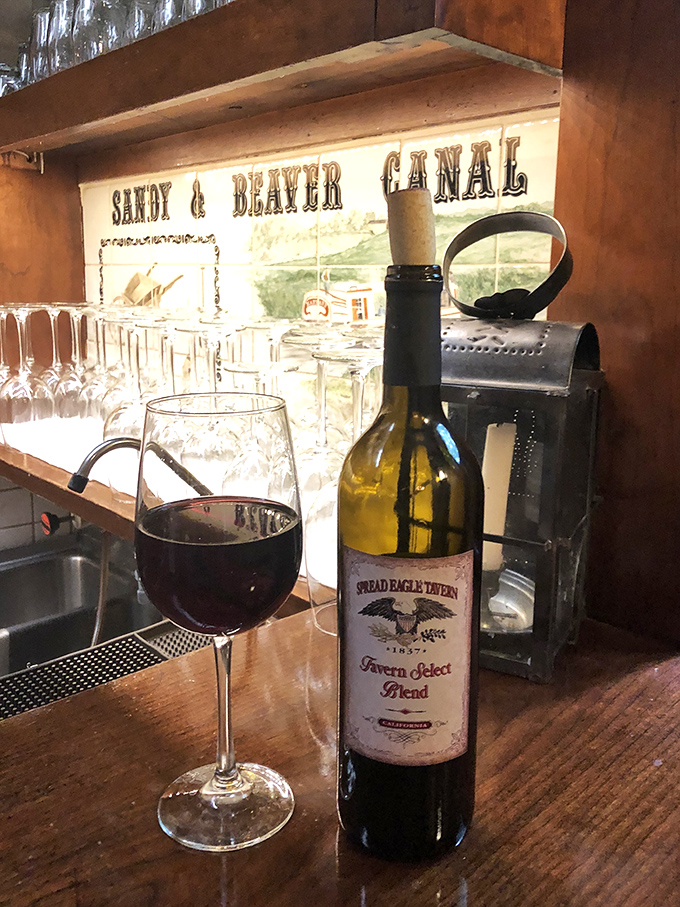 The tavern's own wine sits proudly against a backdrop celebrating local history—proof that good taste and good stories often come from the same place.