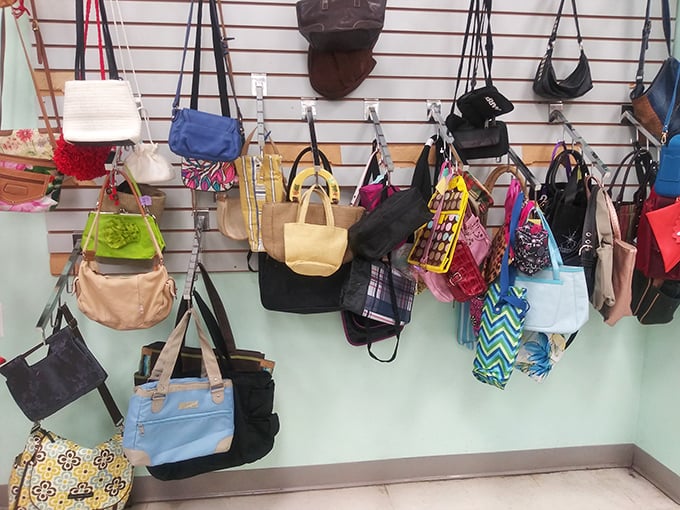 The handbag wall—a colorful tapestry of previous fashion eras where vintage Coach mingles democratically with beach totes and everything in between.
