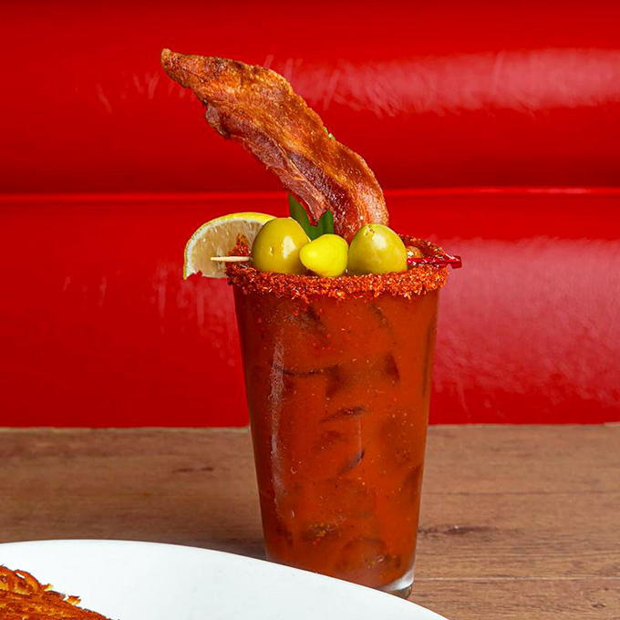A Bloody Mary that doubles as brunch – garnished with bacon that stands at attention and olives that add a salty high-five.