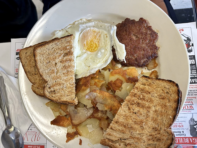 The breakfast trinity—eggs, toast, and home fries—executed with the kind of precision that makes Monday mornings bearable again.