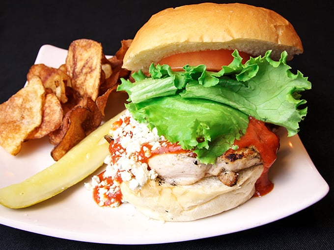 A chicken sandwich that doesn't know it's not the star of the menu—crisp lettuce, juicy tomato, and house-made chips create a lunchtime symphony.