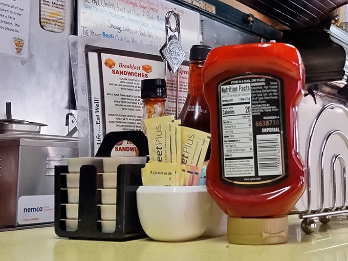 The condiment station—where ketchup bottles stand like sentinels guarding the sacred flavor enhancers of the American diner experience.
