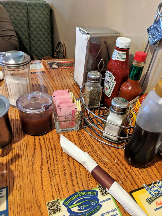 The condiment caddy—that tabletop United Nations of flavor where ketchup, hot sauce, and salt negotiate the terms of your meal's final taste.
