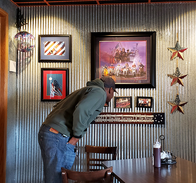 The corrugated metal walls and patriotic decor create an atmosphere that says, "America's greatness can be measured in smoke rings and sauce."