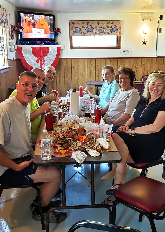 The true measure of a great seafood joint: locals gathered around a table of demolished crab shells, wearing the battle scars of a delicious victory.