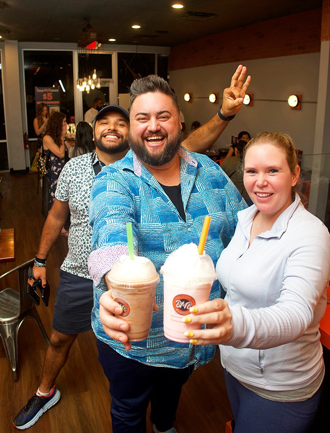 Happy customers clutching milkshakes like trophies. That victory pose says everything about the Build My Burgers experience.