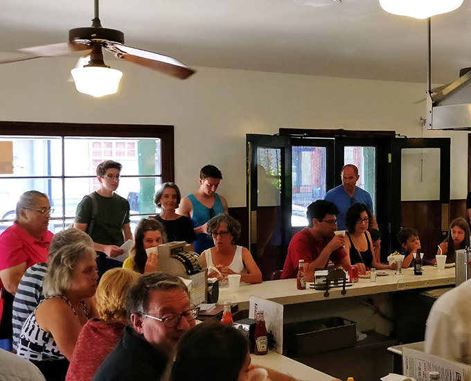 A full house at The Apple Pan isn't just customers—it's a community united by the universal language of "mmmmm." Notice how nobody's looking at their phones?