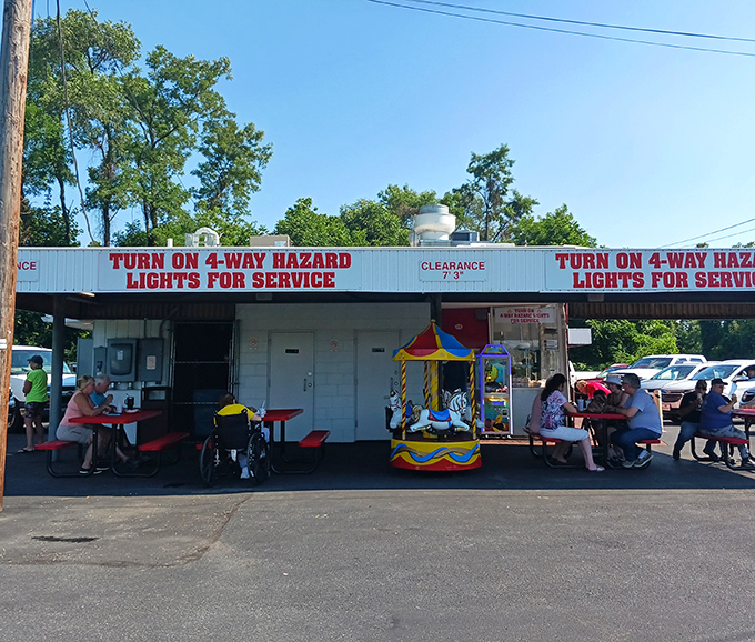 Where strangers become neighbors over shared meals. The sign says "Turn on 4-way hazard lights for service" – a charming ritual from simpler times.