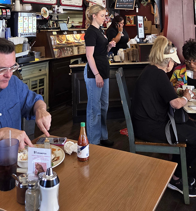The dining room hums with the universal language of good eating. Notice the hot sauce bottle—a necessary accessory for serious chicken enthusiasts.