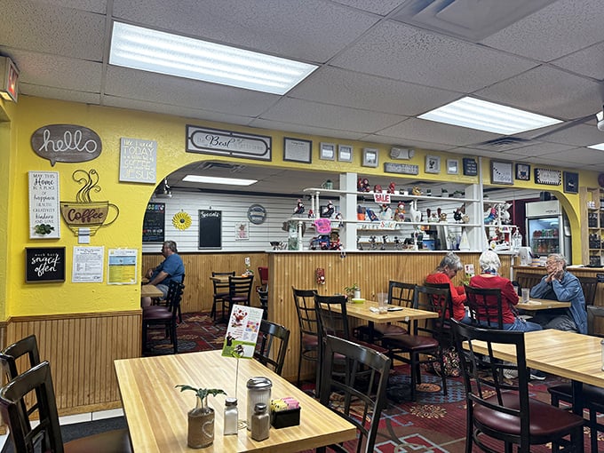 Cheerful yellow walls adorned with coffee-themed signs create the backdrop for what matters most – locals enjoying their breakfast favorites.