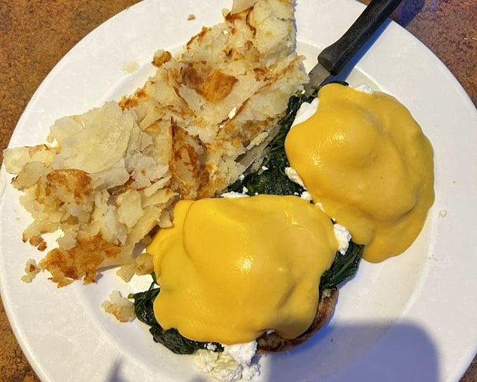 Eggs Benedict with spinach—where hollandaise sauce flows like liquid sunshine over perfectly poached eggs. Breakfast architecture at its finest. 