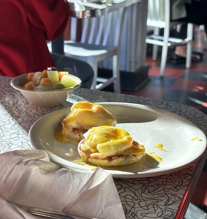 Eggs Benedict done right—with hollandaise sauce cascading down like a yellow waterfall of buttery goodness.