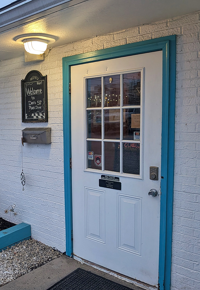 The entrance says it all—white door, turquoise trim, and a chalkboard welcome. No pretension, just the promise of good food and better conversation.