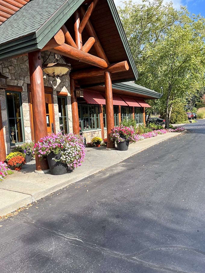 The entrance blooms with Michigan wildflowers, a colorful welcome that softens the lodge's rugged timber and stone façade.