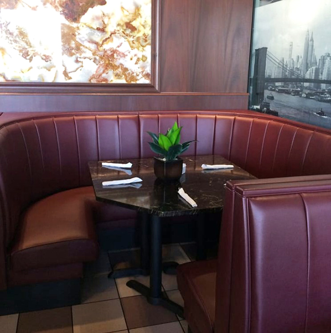 The corner booth—diner real estate at its finest. That marble-topped table has probably witnessed more heart-to-hearts than a therapist's couch.