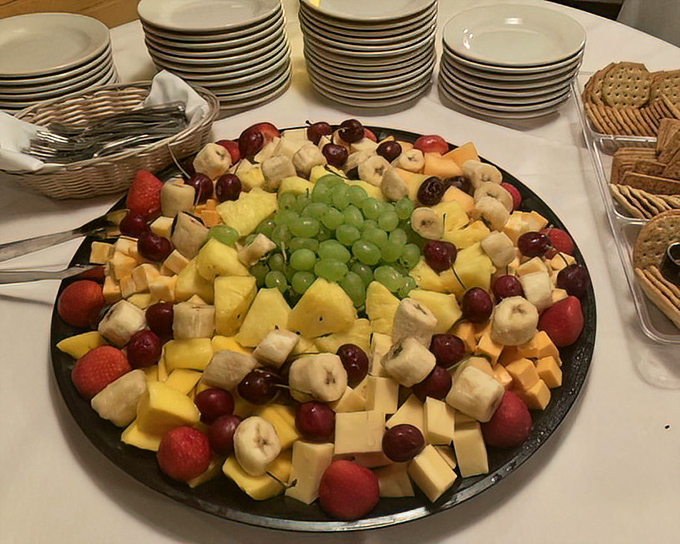 This fruit and cheese platter isn't just appetizing – it's architectural. The grapes form a verdant dome over a landscape of dairy and fruity delights.