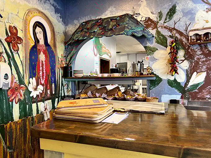 The kitchen pass reveals glimpses of culinary magic happening behind the scenes. That Virgin Mary mural isn't just decoration—she's overseeing quality control.