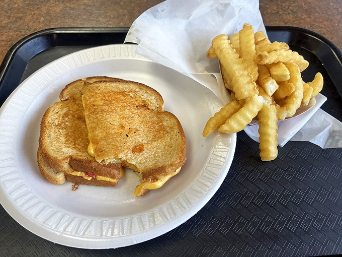 Grilled cheese perfection isn't complicated—just perfectly toasted bread, melty American cheese, and the crinkle-cut fries of your childhood dreams.