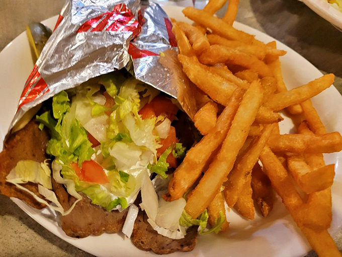 This gyro isn't just wrapped—it's embraced. Fresh veggies and seasoned meat cozied up with crispy fries that refuse to be mere sidekicks.