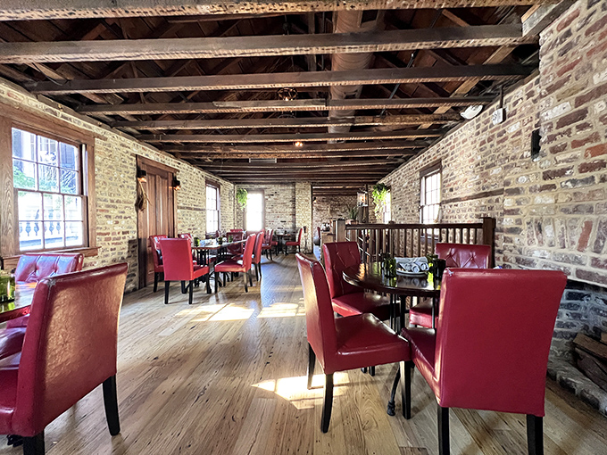 Exposed brick walls tell stories while red leather chairs invite you to stay awhile—this dining space feels like the coolest history class you've ever attended.