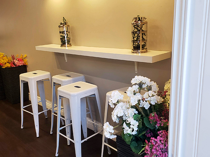 White metal stools and fresh flowers create a small oasis where you can contemplate the important things in life—like whether to order a second dessert.