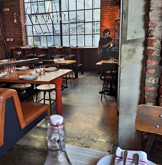 The restaurant's industrial bones create a dining room that feels both intimate and electric—like eating in the world's coolest factory.