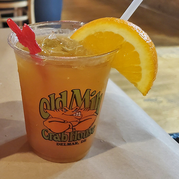 A sunset in a glass with that little red sword—because every proper drink deserves its own weapon and a slice of citrus armor.