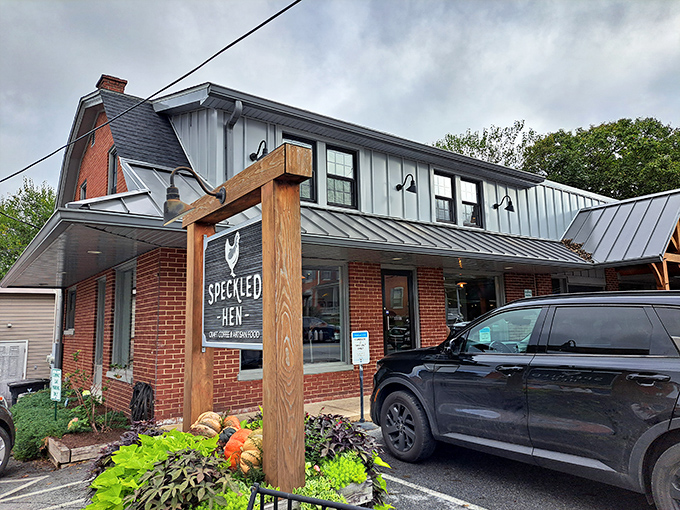 Even on cloudy days, Speckled Hen's charming exterior beckons breakfast enthusiasts with its rustic wooden sign and inviting brick façade.