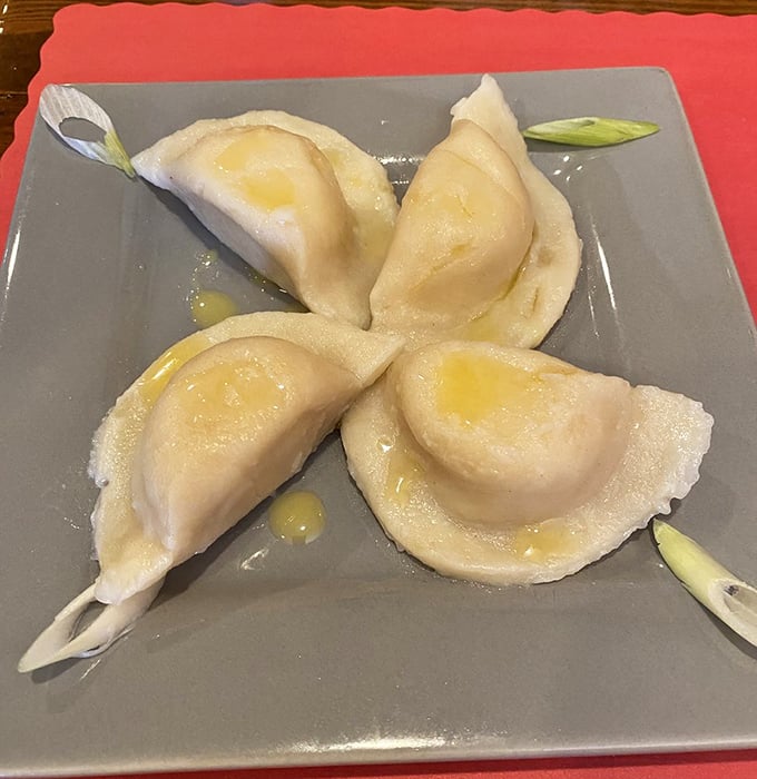 Pierogi perfection in its purest form. These plump dumplings glisten with butter like morning dew on lily pads—if lily pads were delicious.