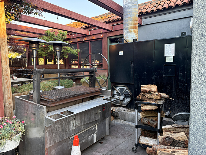 The beating heart of barbecue magic—wood stacked beside a serious smoker. This isn't cooking; it's a time-honored ritual of patience and fire.