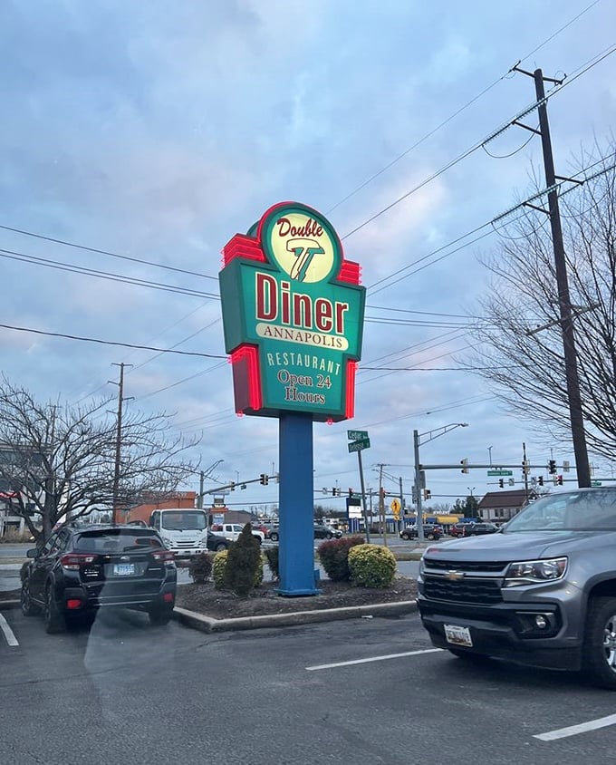 That neon sign glowing against the twilight sky isn't just advertising—it's a lighthouse guiding hungry souls to 24-hour breakfast salvation.