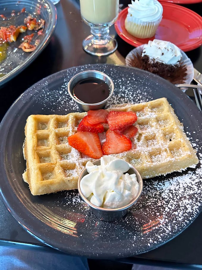 Waffle perfection isn't complicated—crisp exterior, fluffy interior, fresh strawberries, and enough powdered sugar to make your dentist wince. Worth every calorie.